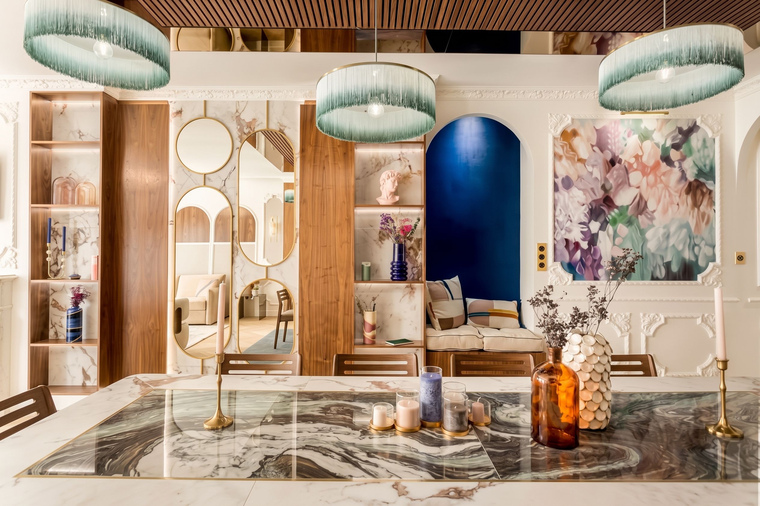 Um interior moderno com uma mesa de mármore, espelhos decorativos e uma parede azul de destaque.