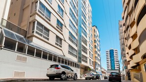 Um edifício de vários andares com design moderno, com varandas e grandes janelas.