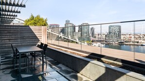 Terraço com vista para o horizonte urbano e um corpo de água.