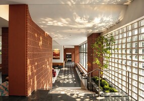 Um interior moderno com uma escada, uma área de estar e uma parede com padrão em grade.