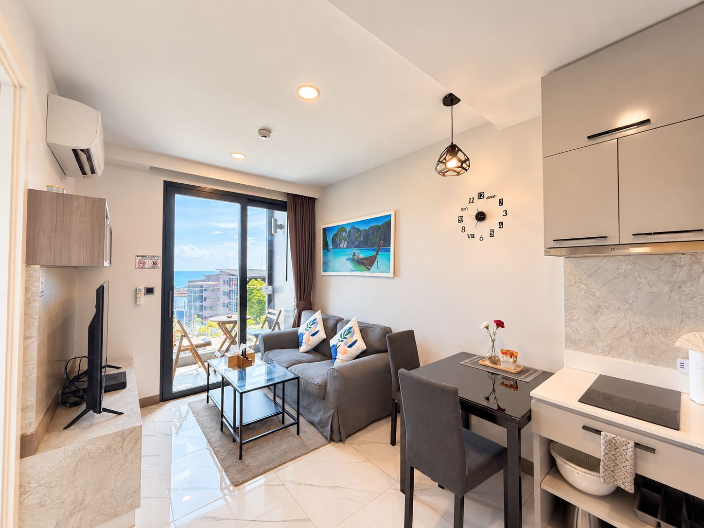 Um apartamento moderno com varanda, área de jantar, cozinha e sala de estar.