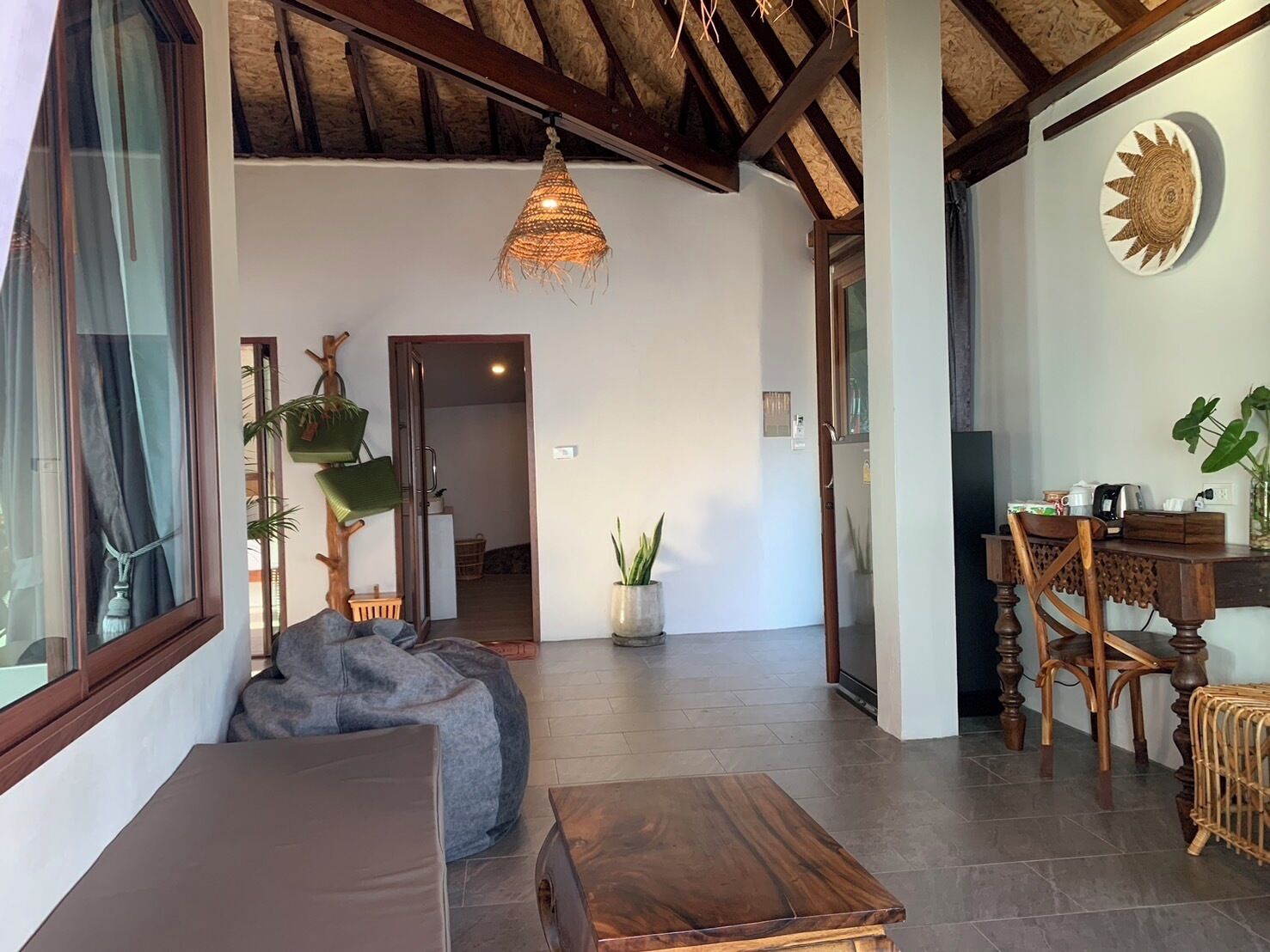 Uma sala ampla com teto alto, uma mesa de jantar de madeira e um espaço de estar aconchegante.