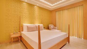 Quarto moderno com cama grande, cabeceira de madeira e mesa de cabeceira com duas garrafas.