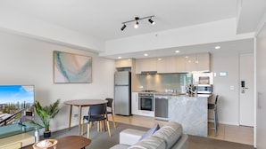 Um apartamento moderno com sala de estar, área de jantar, cozinha e varanda com vista para a cidade.