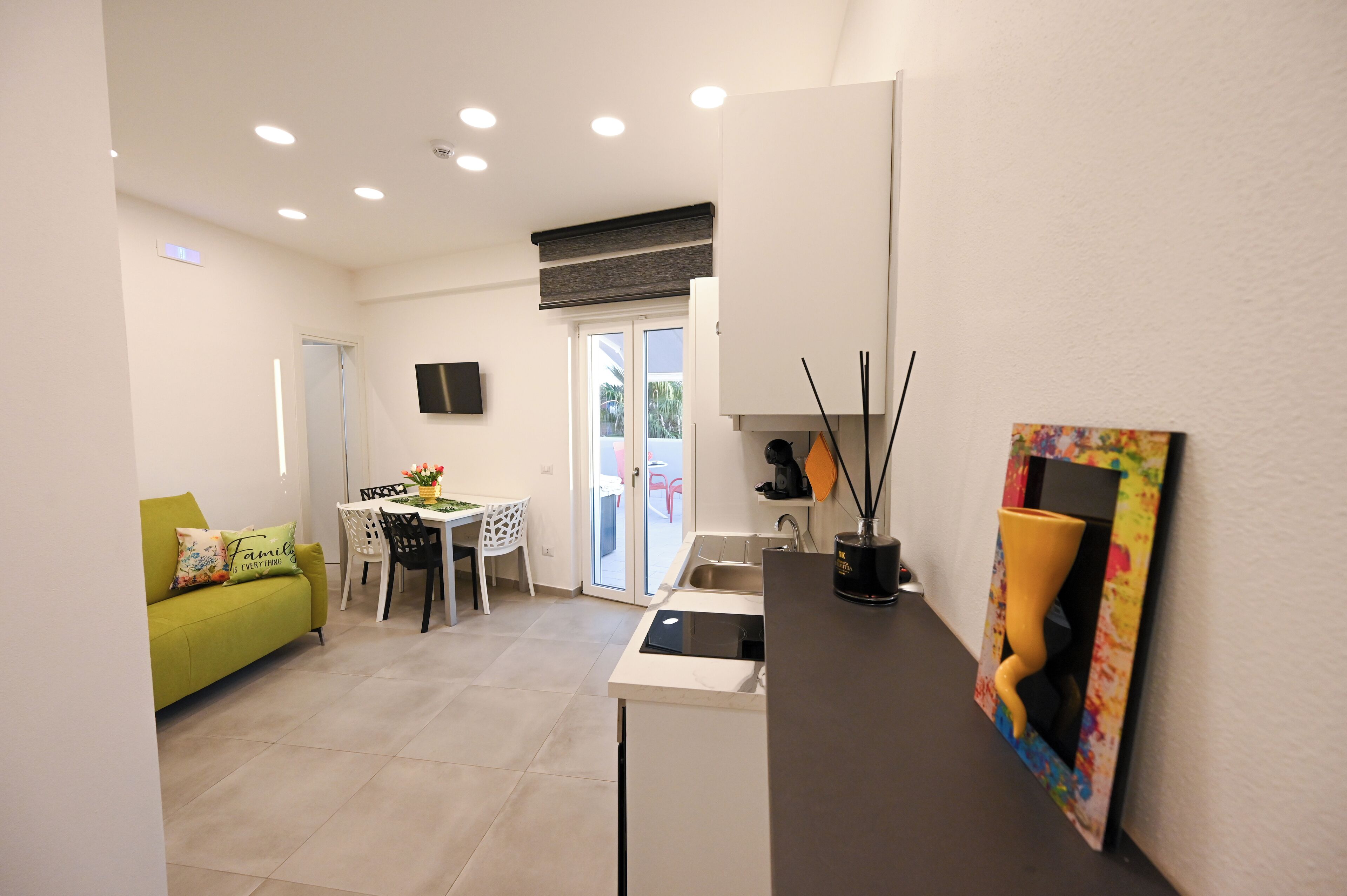 Um espaço compacto com cozinha compacta, área de refeições e sofá.