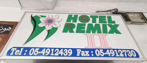 Placa de hotel com o nome 'HOTEL REMIX' e números de contato.