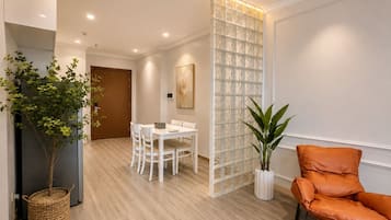 Decoração moderna com sala de jantar, área de estar com poltrona de couro e planta decorativa.
