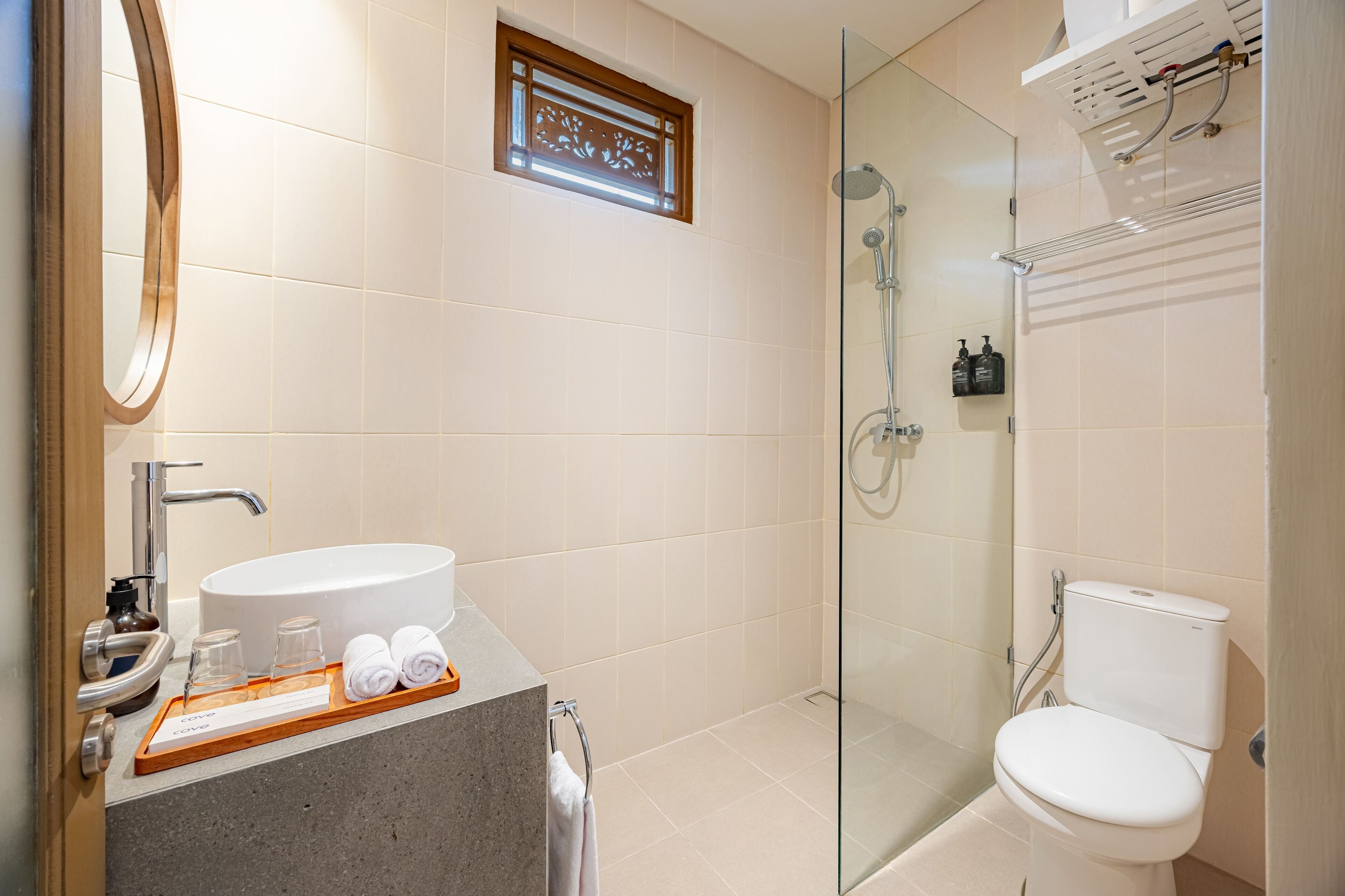 Uma casa de banho moderna com chuveiro de vidro, lavatório branco e sanita.