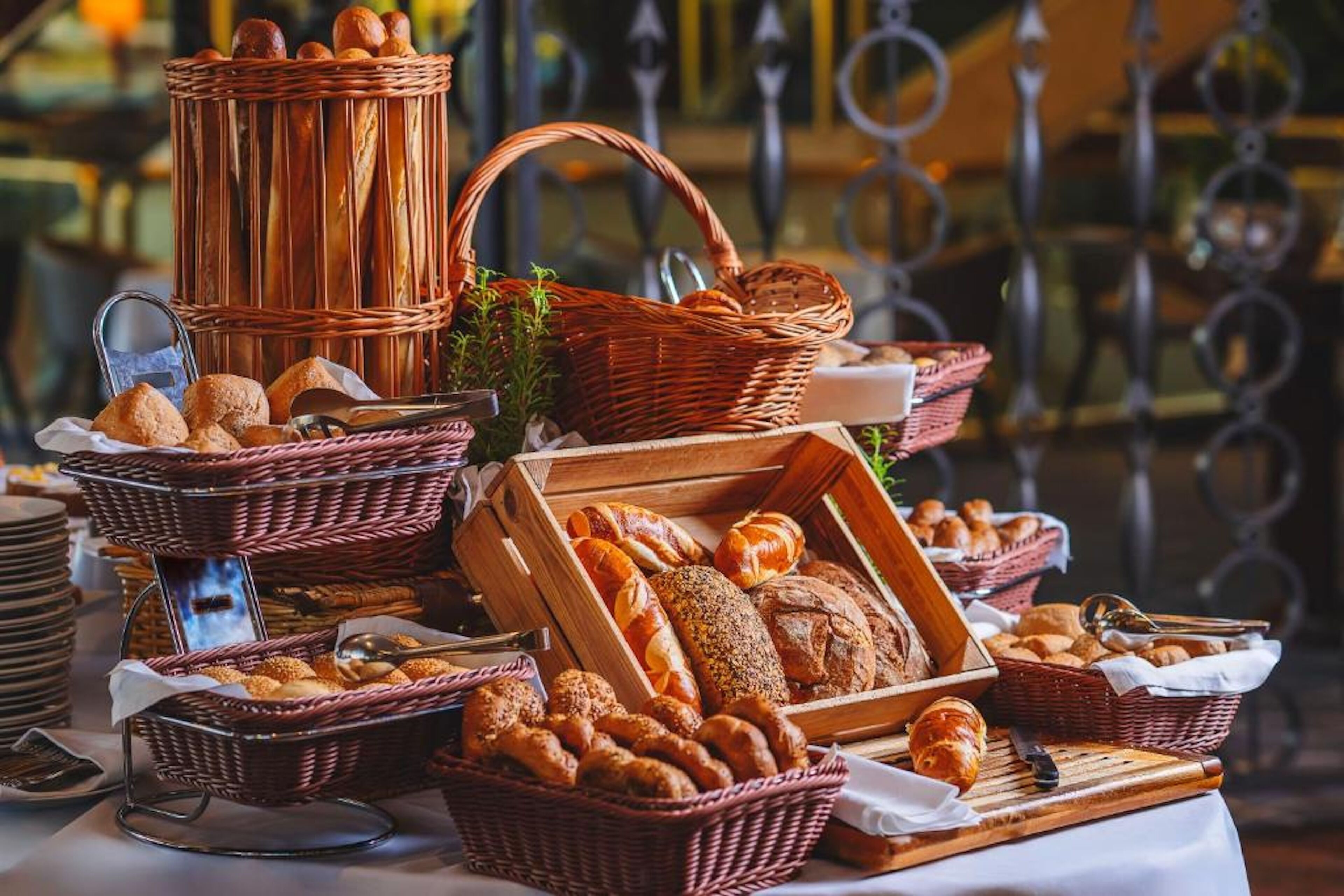 Uma mesa de buffet com diversos tipos de pães e doces.
