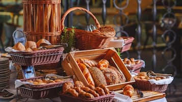 Uma mesa de buffet com diversos tipos de pães e doces.