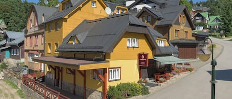 Um edifício amarelo com uma placa que diz 'Windsor' e uma placa menor com 'U Komarka' indicando um restaurante.