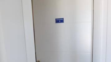 Uma porta fechada com uma placa azul que diz 'EATRE 1'.