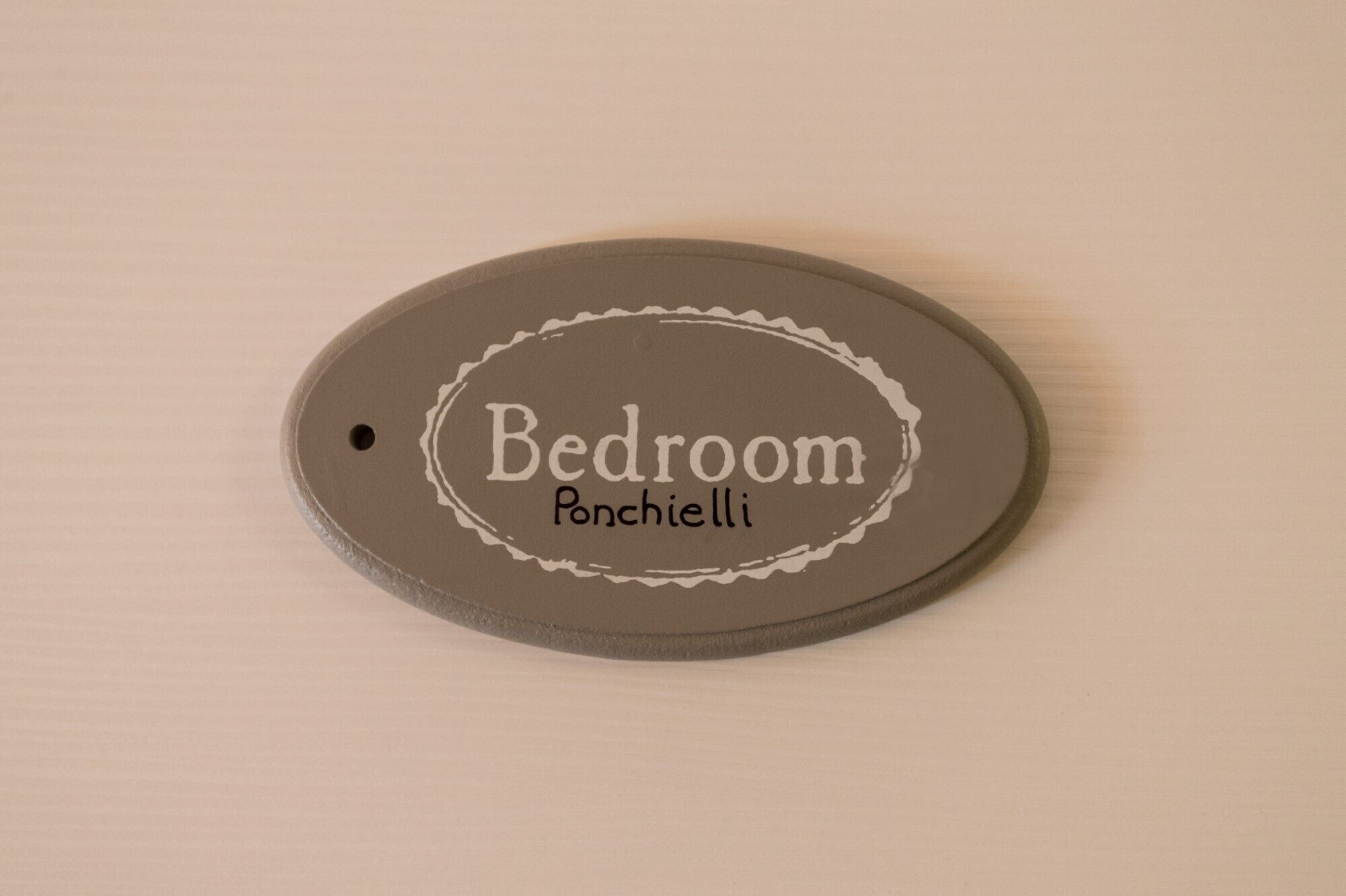 Etiqueta com o texto "Bedroom" e "Panchieli" sobre um fundo bege.