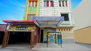 Um edifício com fachada colorida, entrada coberta e placa indicando um restaurante.