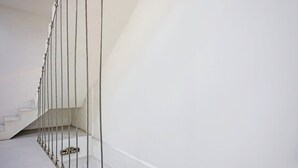 Uma escada com corrimão de metal e uma placa indicando a saída.