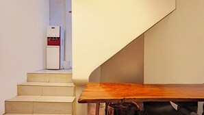 Escadaria que leva a um quarto com uma mesa de madeira e uma cadeira.