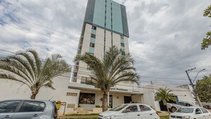 Um edifício alto com design moderno, combinando vidro e concreto.