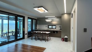 Uma cozinha moderna com área de jantar, janelas amplas e vista para o exterior.