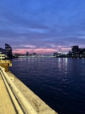 Vista para a orla marítima com uma ponte, edifícios e uma grua.