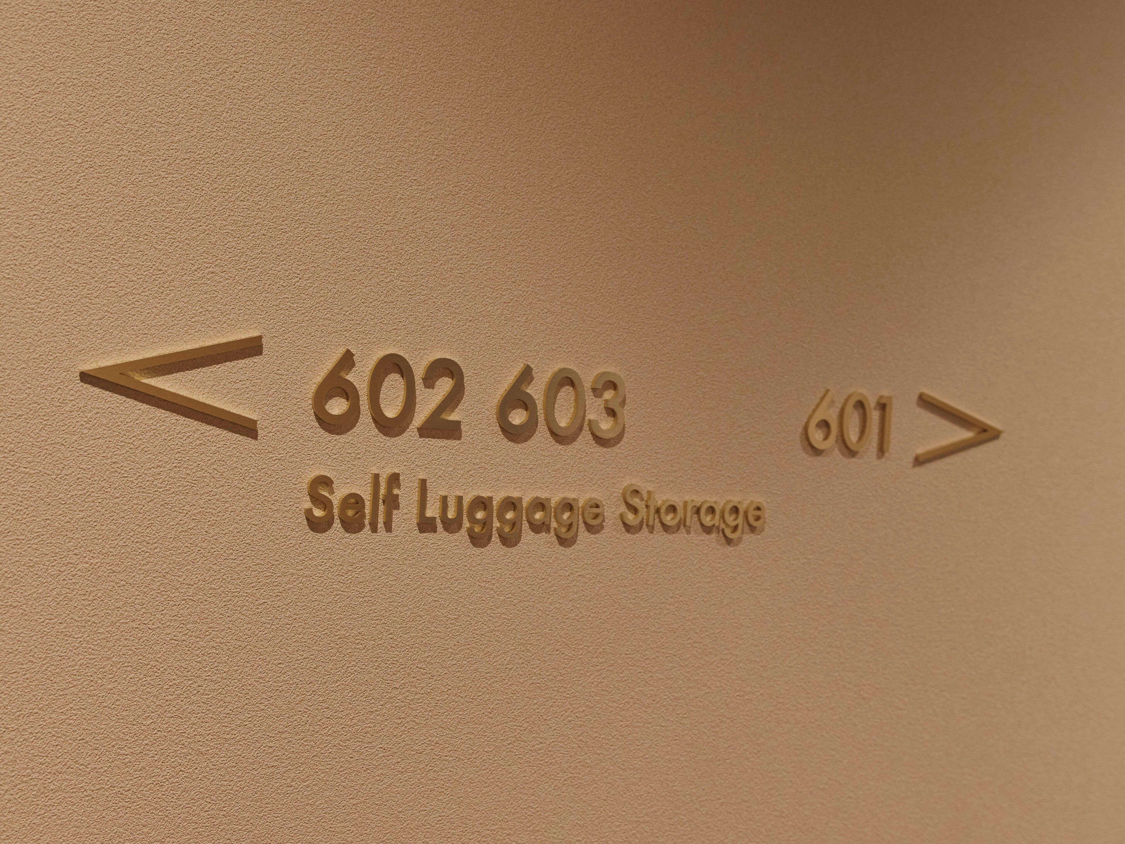 Placa indicativa para depósito de bagagem com os números 602, 603 e 601.