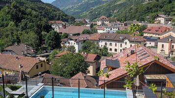 Zona residencial com casas, piscina e montanhas ao fundo.