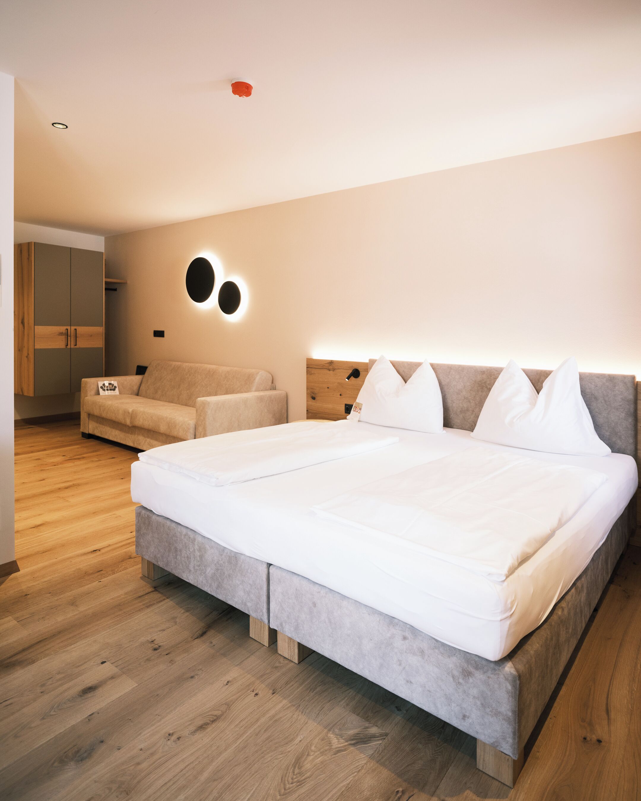 Quarto moderno com cama grande, um sofá e um guarda-roupa.