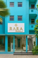Um edifício com fachada turquesa e uma placa com o texto 'RARA'.
