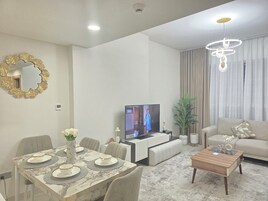 Apartamento superior, vista para o mar | Área de estar | Smart TV 65 polegadas com canais digitais, serviços de streaming