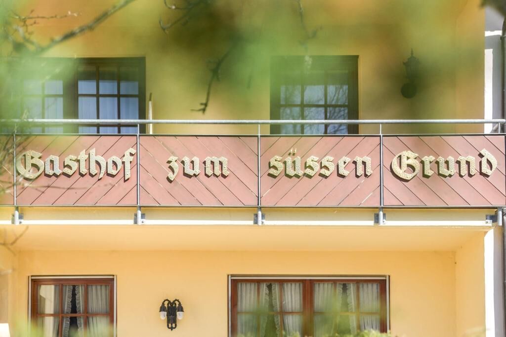 Um edifício com uma placa que diz 'Gasthof zum sissen Grund'.