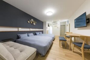 Um quarto com uma cama, um sofá, uma escrivaninha e uma cadeira.