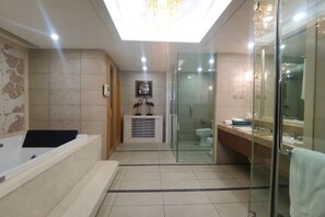 Uma casa de banho moderna com cabine de duche em vidro, banheira e toucador com espelho.