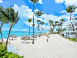 Perto da praia, praia de areia branca, espreguiçadeiras 