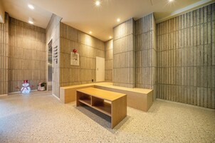 Casa de banho moderna e minimalista com um banco de madeira, sanita e área de duche.