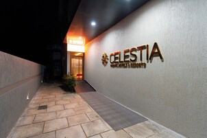 Um corredor com uma placa indicando "CELESTIA" e entrada de um edifício.