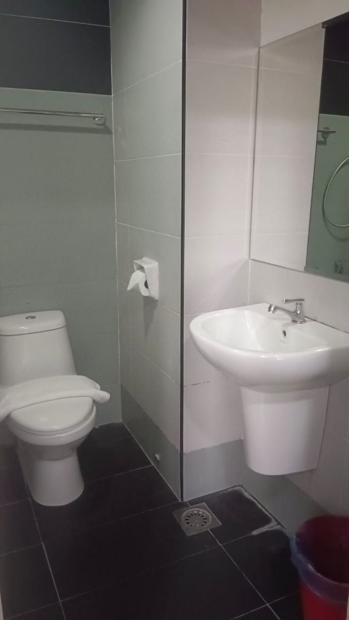 Casa de banho com sanita, lavatório e zona de duche.
