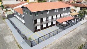 Um edifício com vários andares e uma área de estacionamento na frente.