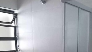 Casa de banho com sanita, bidé e cabine de duche envidraçada.