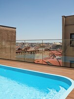 Piscina no terraço com vista ampla para a paisagem urbana.