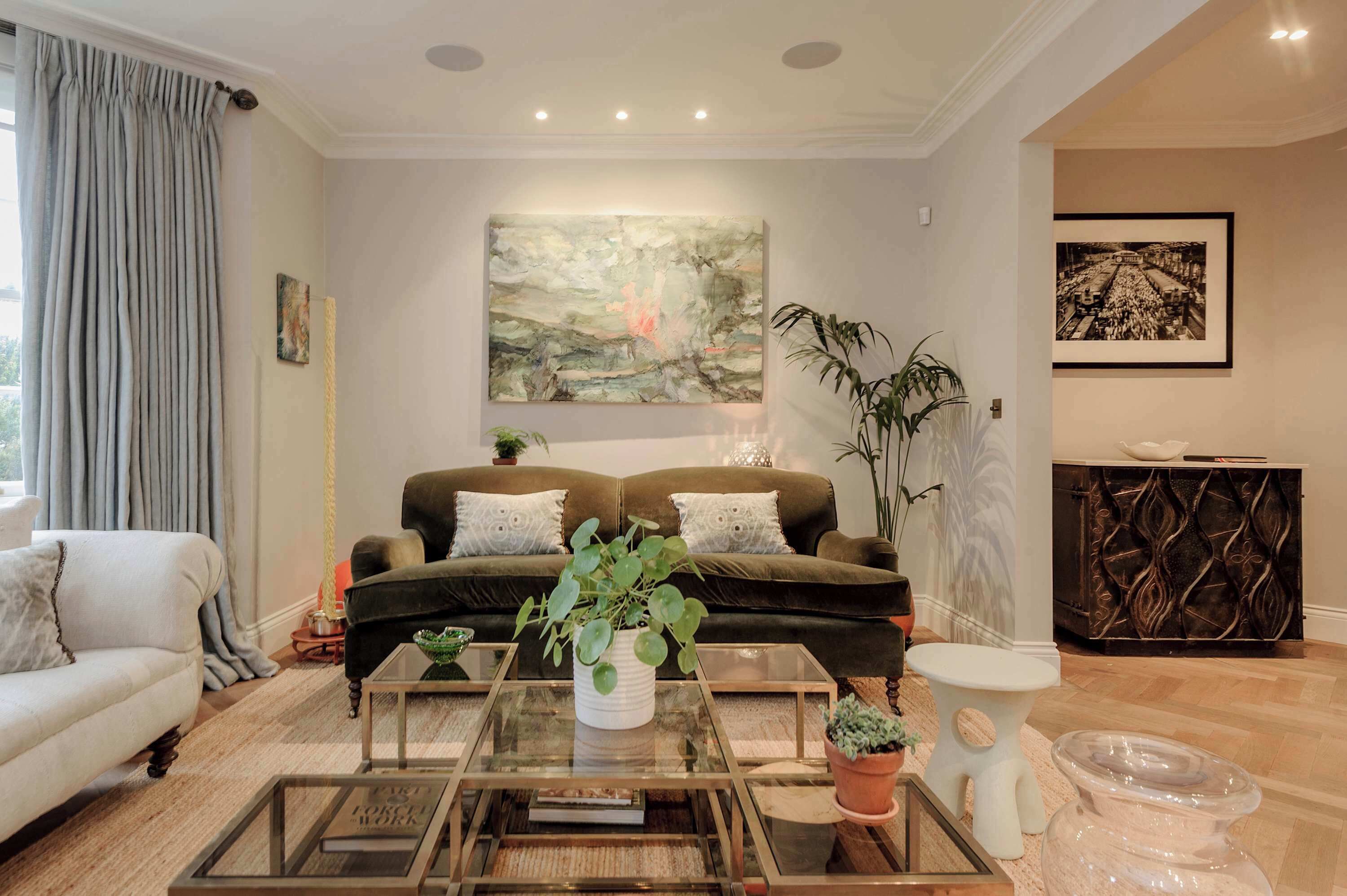 Uma sala de estar com um sofá, uma mesa de centro e um quadro na parede.