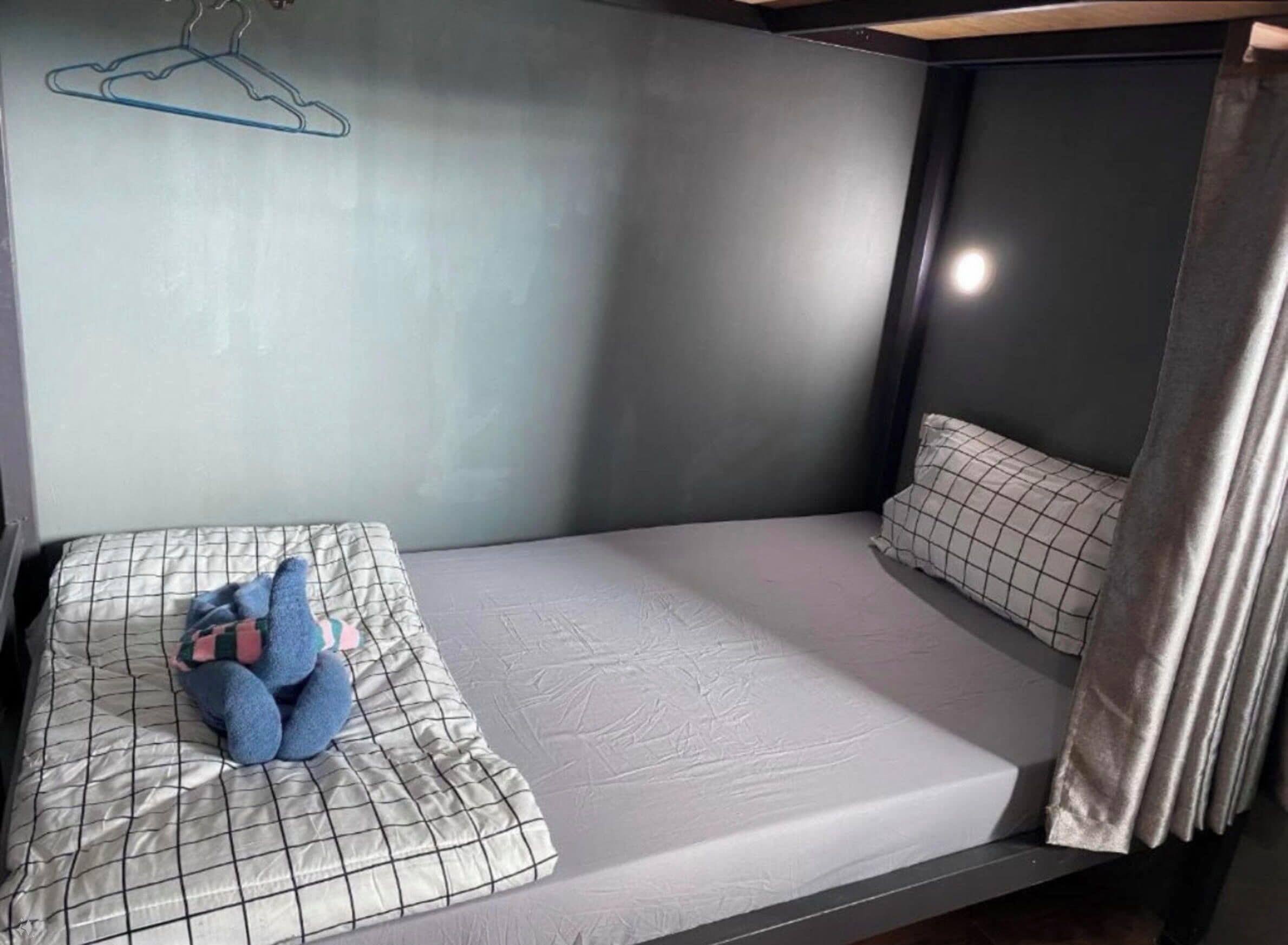 Uma cama beliche com um cabideiro pendurado acima.
