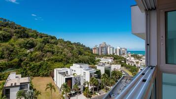 Zona residencial com edifícios modernos, céu claro e vista para o mar.