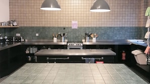 Cozinha com duas luminárias pendentes, fogão a gás e painel de azulejos.