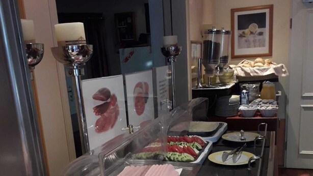 Buffet com diversos alimentos, incluindo ovos, carnes e frutas.
