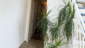 Uma escadaria com corrimãos brancos e uma porta que dá para outro cômodo.