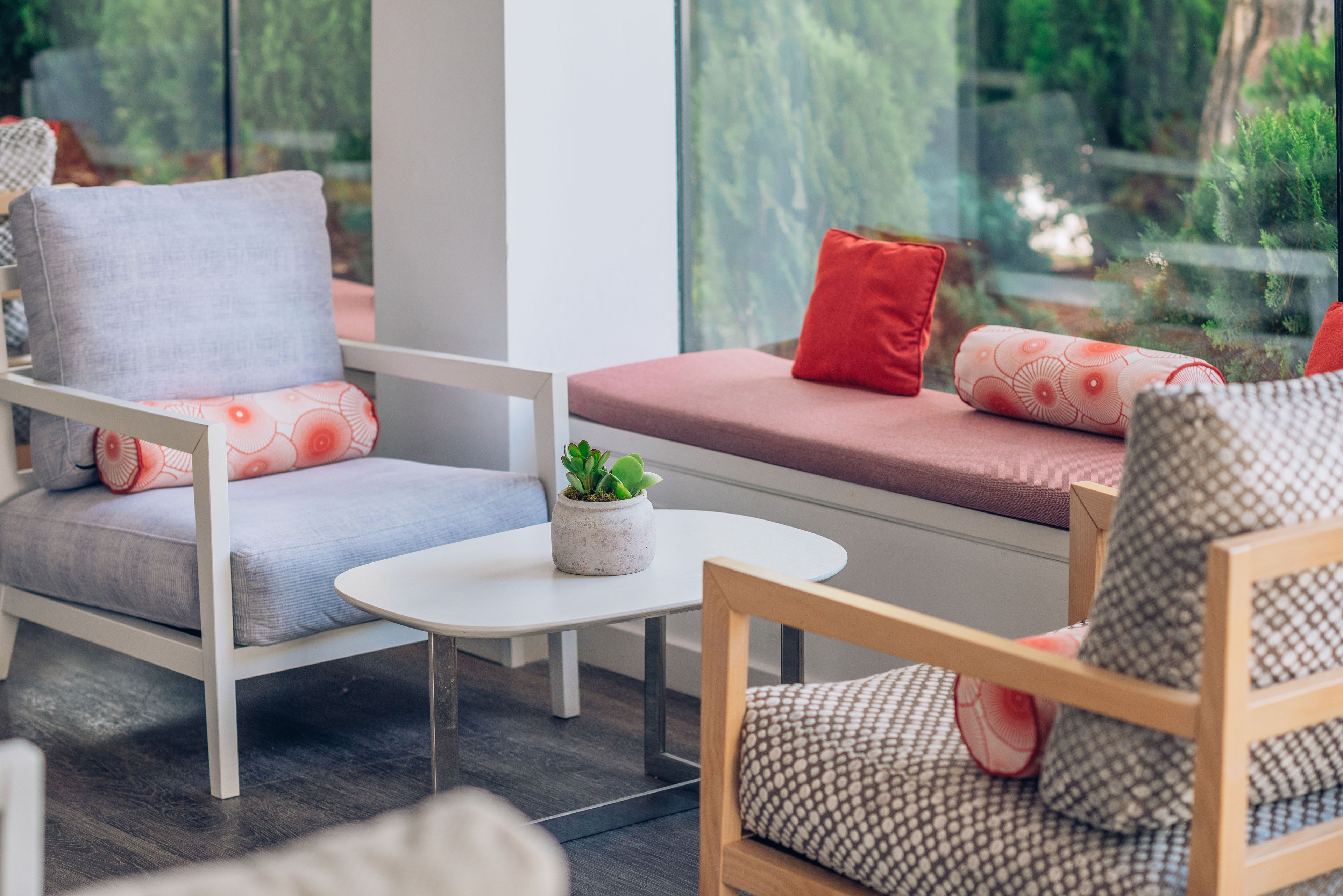 Uma sala de estar moderna com sofá, poltronas e uma pequena mesa.