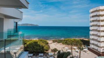 Um edifício moderno com varanda com vista para a praia e o mar.