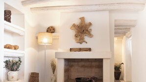 Uma sala de estar aconchegante com lareira, decoração em madeira e uma luminária de chão.