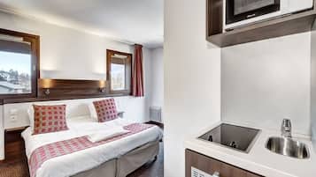 Quarto de hotel com cama, janela com vista, micro-ondas e pia.