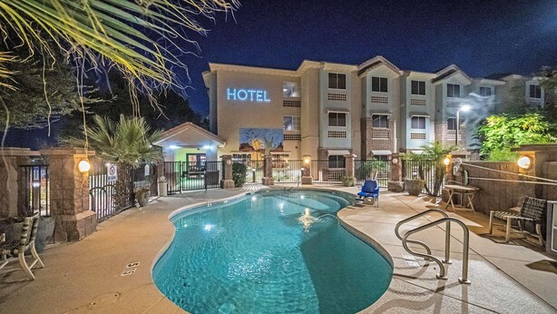 Um hotel com piscina, área de estar externa e placa indicando classificação de 5 estrelas.