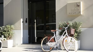Uma bicicleta estacionada em frente a um prédio com uma placa que diz "Map holiday residence".